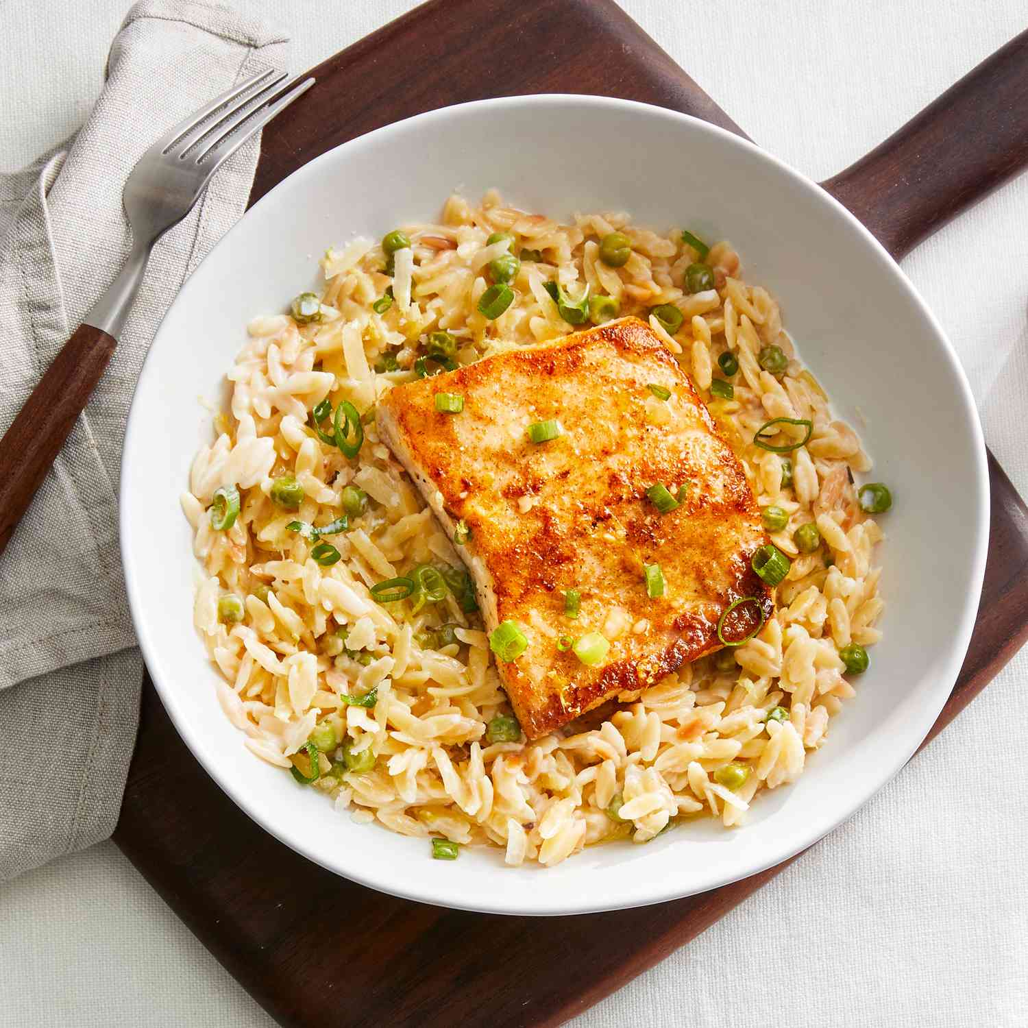 Lemon-infused fish served alongside a creamy orzotto, making for a ...
