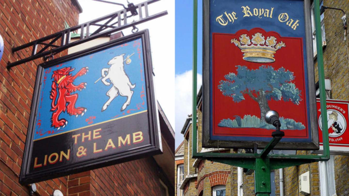 Why are British pubs adorned with artistic signs outside?
